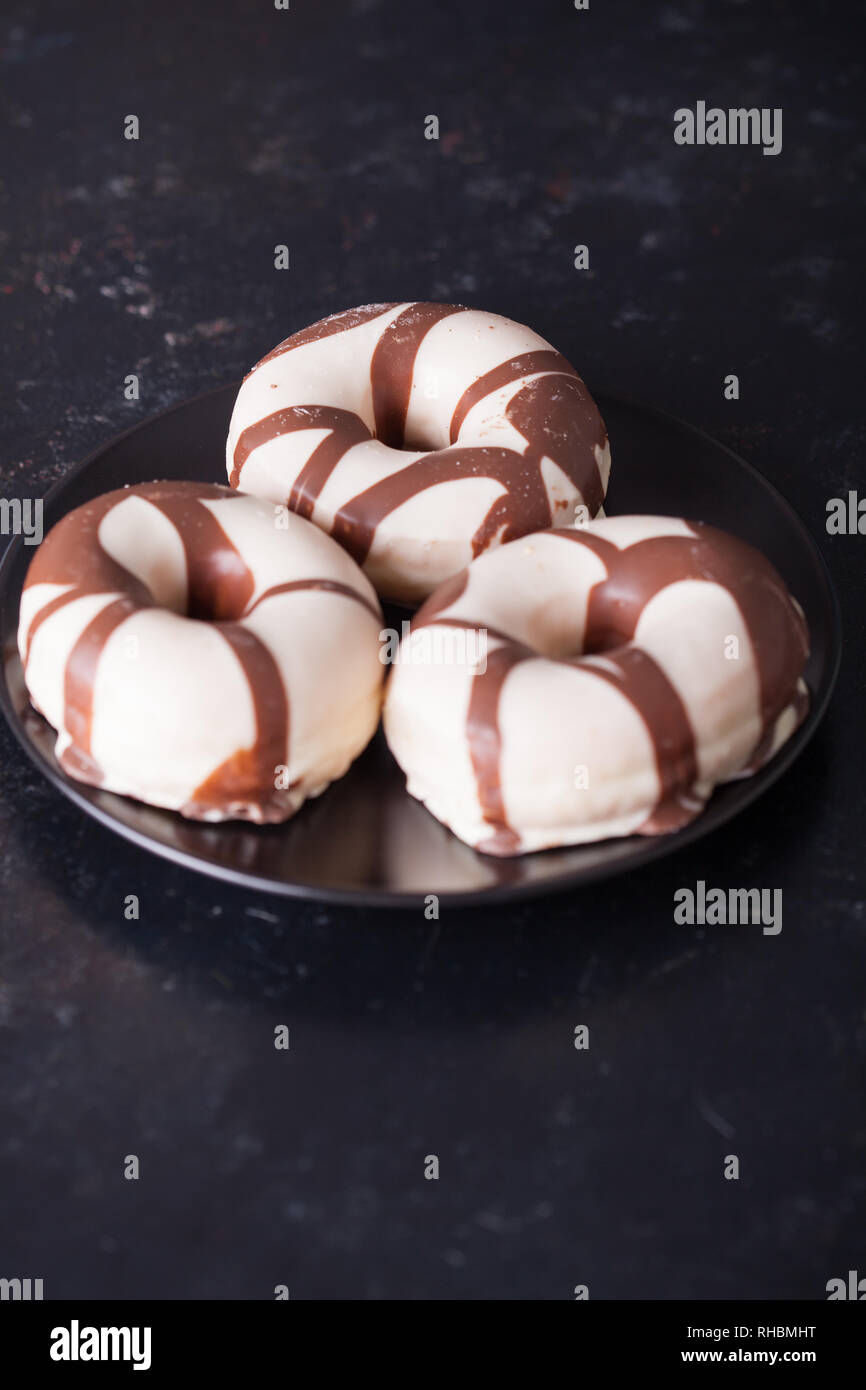 Striped donuts on dark wooden table. Delicious snack Stock Photo - Alamy