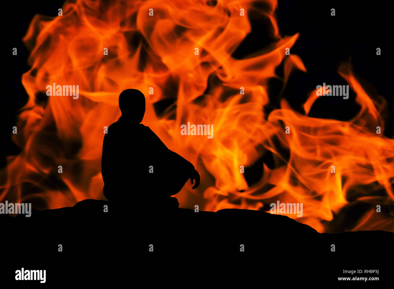silhouette of a monk, meditating on fire background Stock Photo - Alamy