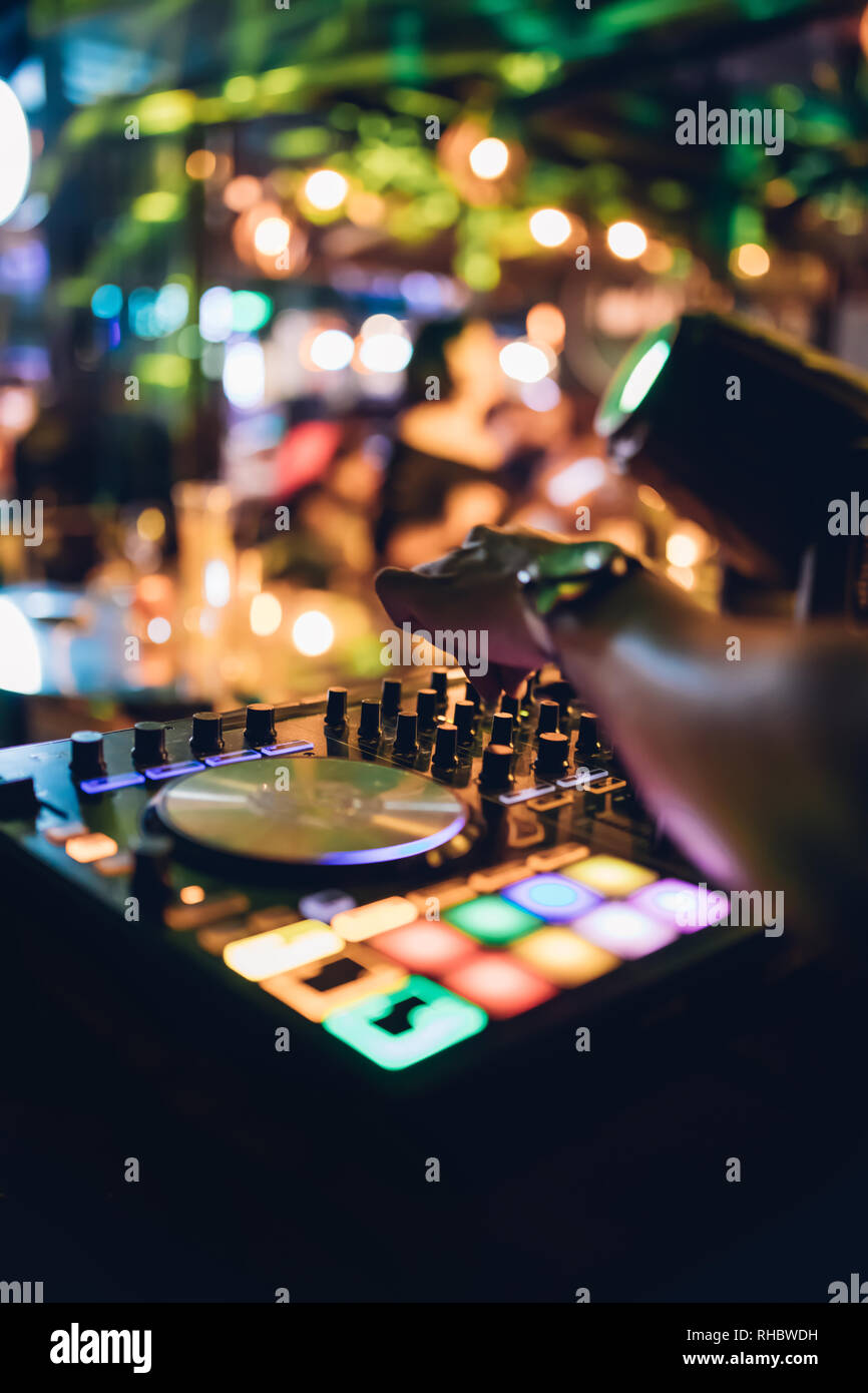 DJ plays live set and mixing music on turntable console at stage in the ...