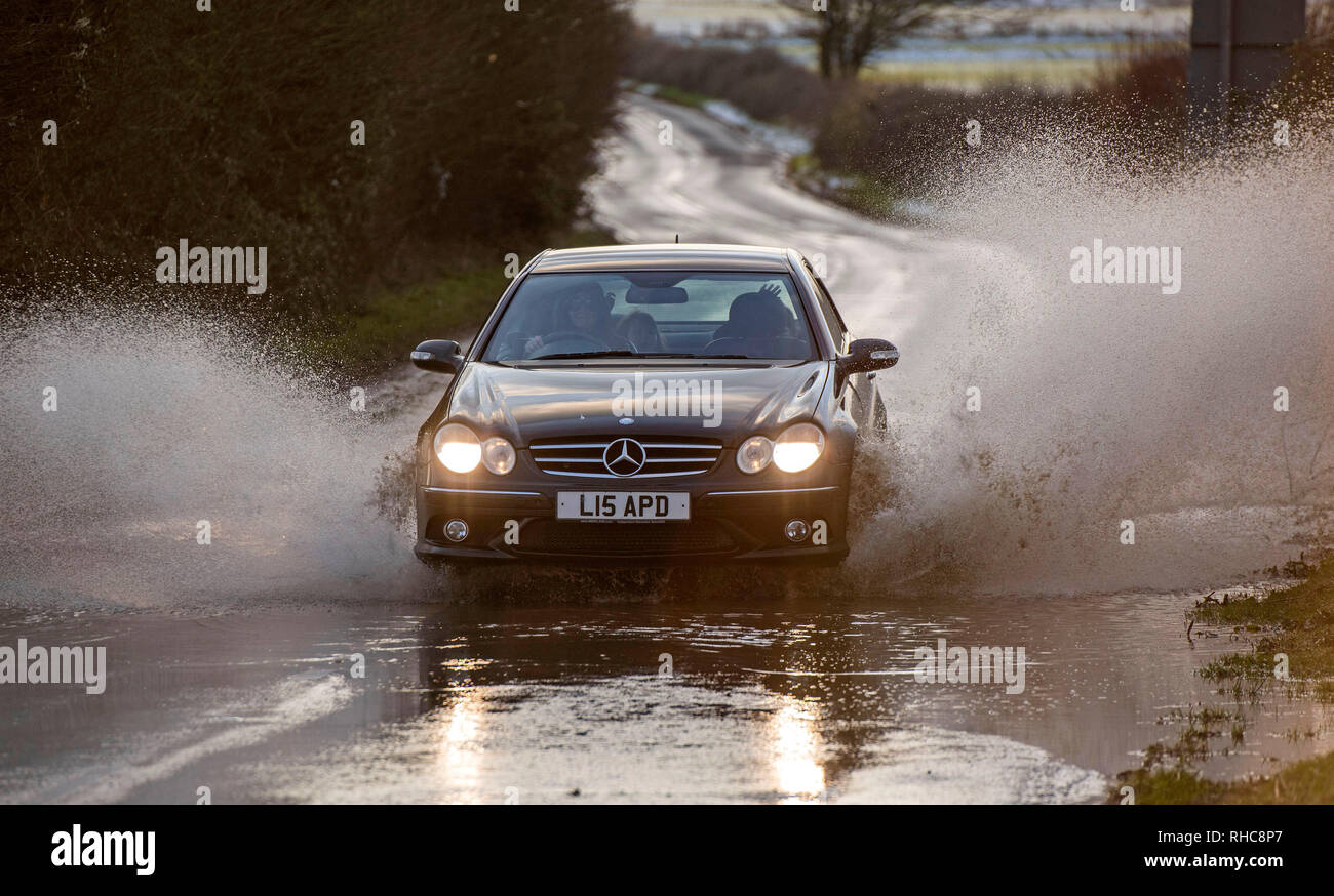 Motorists driving through a flood on the main road at Scurlage on the ...