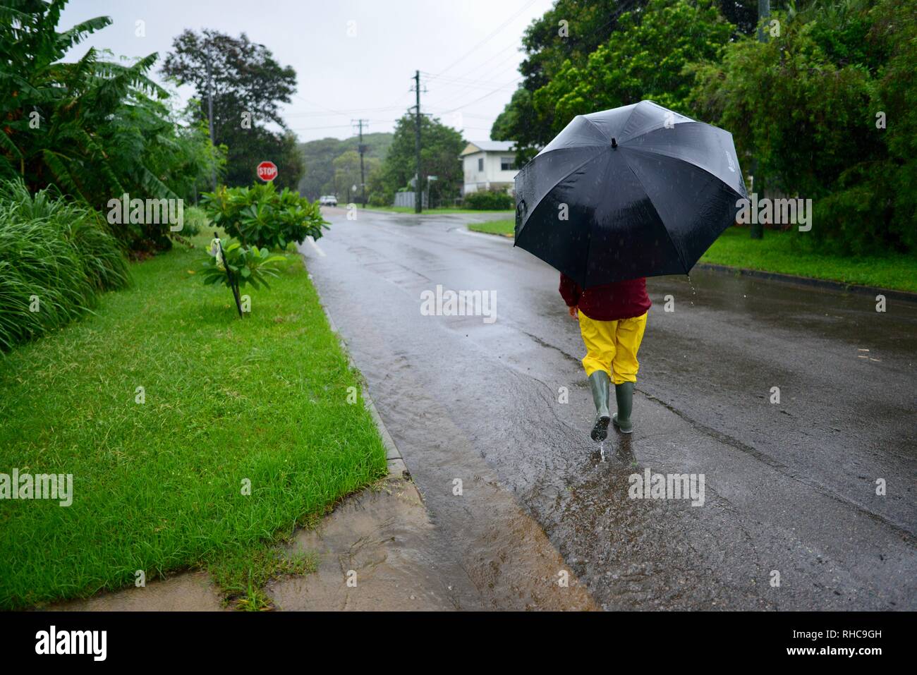 A woman in a red rain jacket wades through flood waters. Flooding ...