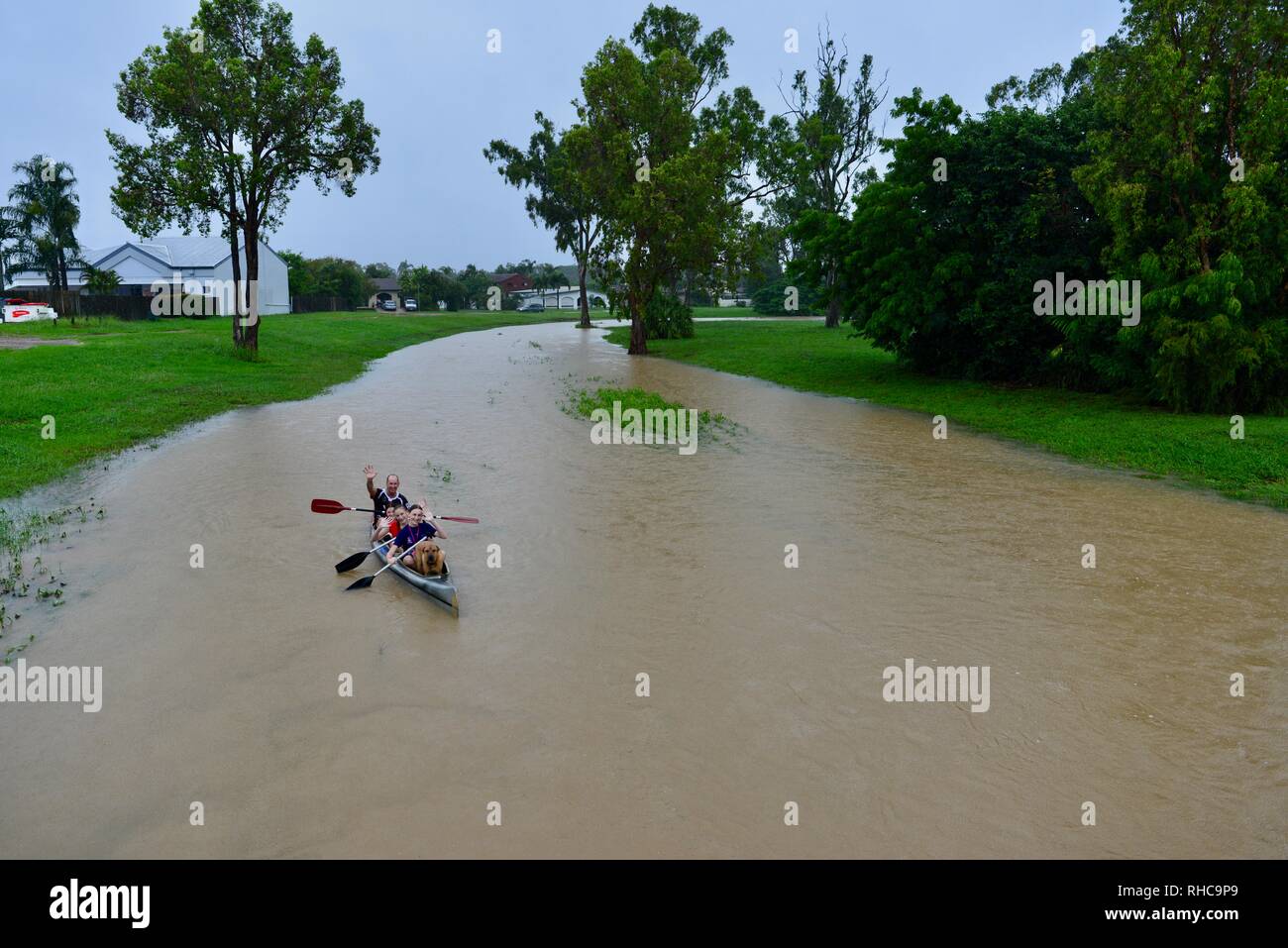 A family canoe in a flooded drainage channel, Flooding continued to ...