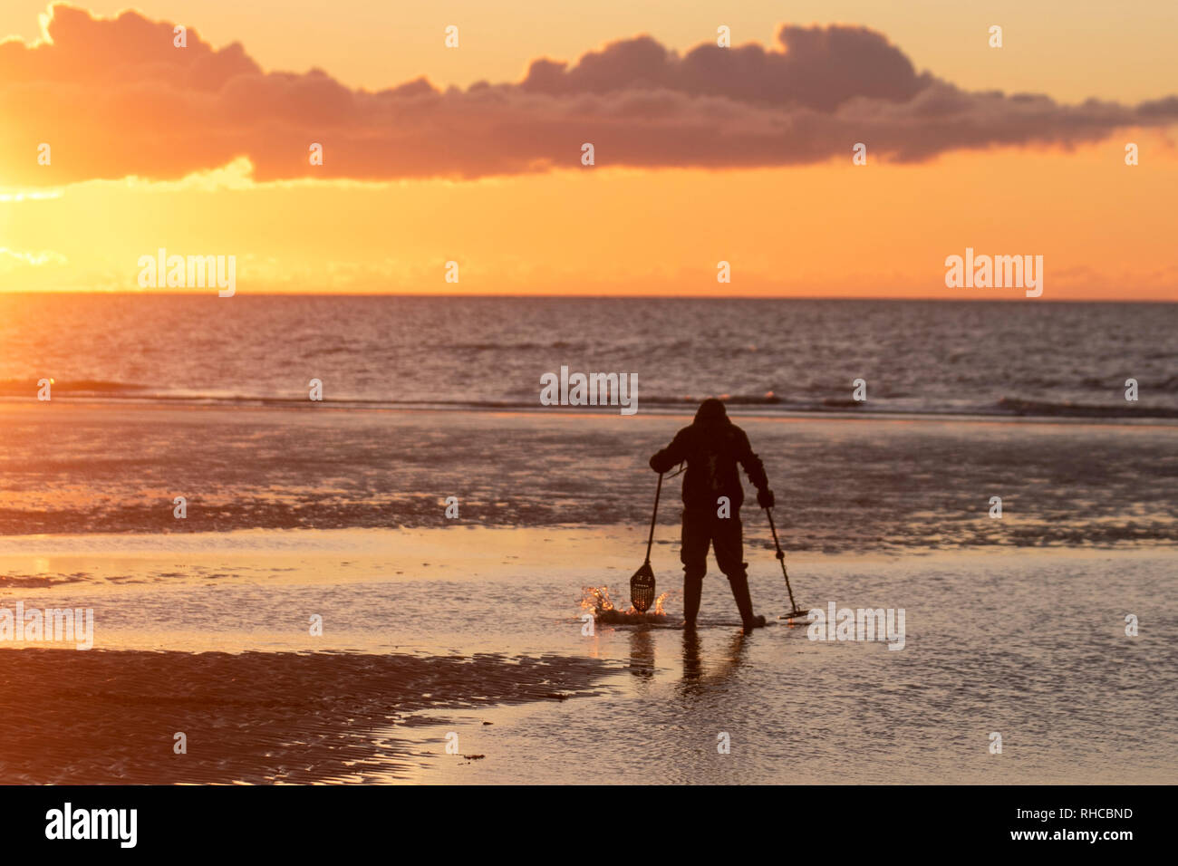 Two metal detectorists with a shovel and a spade scour Blackpool beach ...