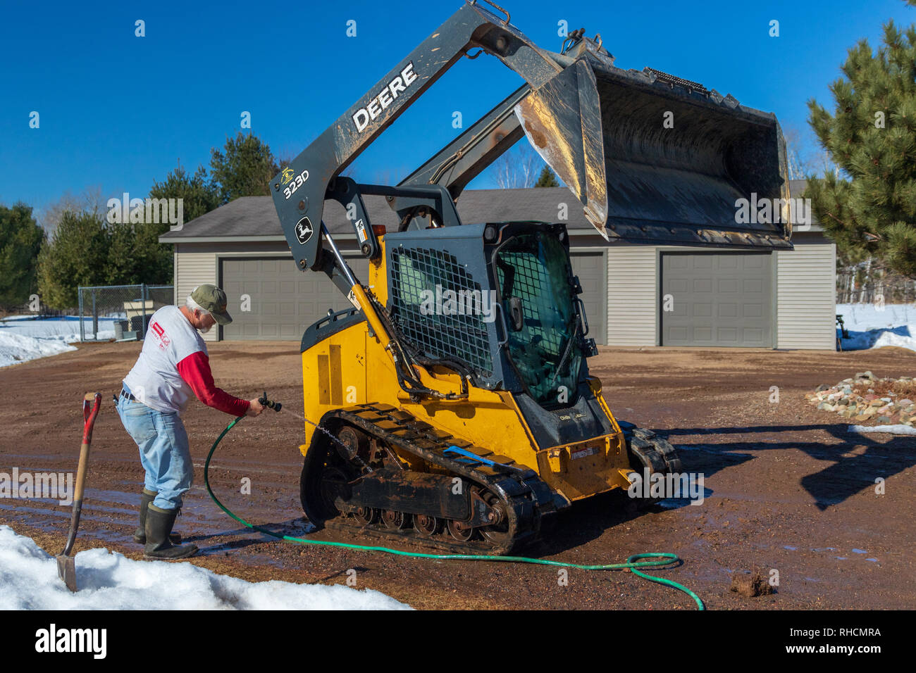 Man hosing off a John Deere Track Loader Stock Photo - Alamy