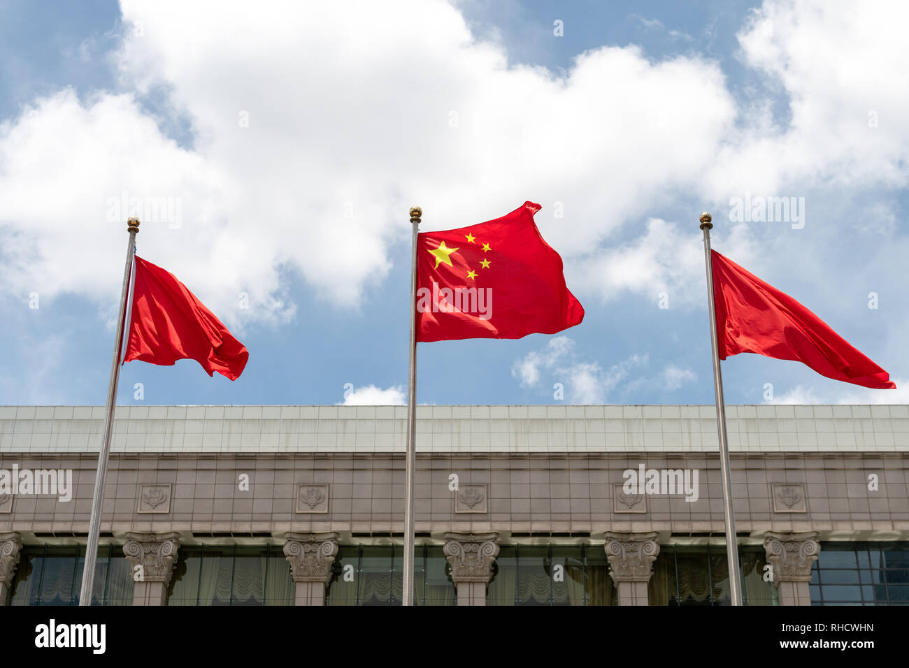 Chinese national flag flying from a pole with building roof in ...