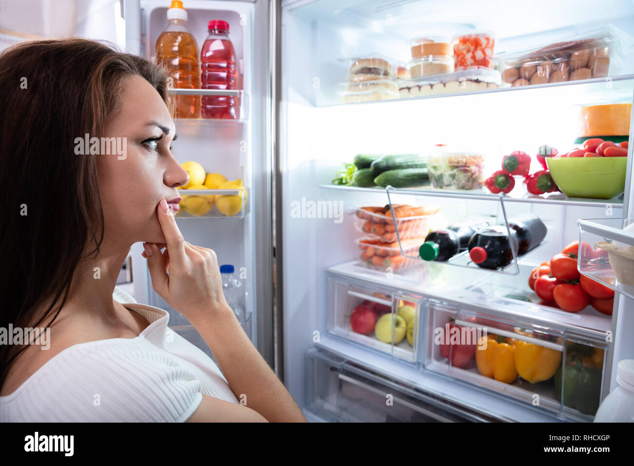 Pretty Woman Looking For Food In Refrigerator Stock Photo - Alamy