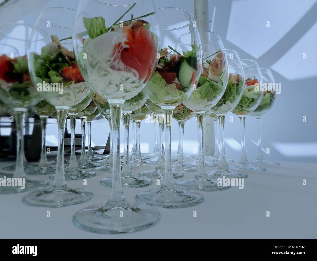 Salad cocktail with vegetable mix and white sauce in glasses on the ...