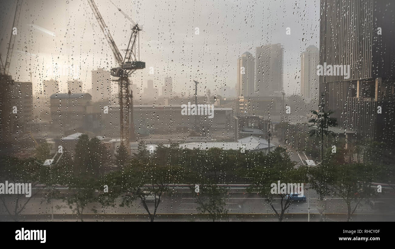 A crane in heavy rain is working on building a skyscraper Stock Photo ...