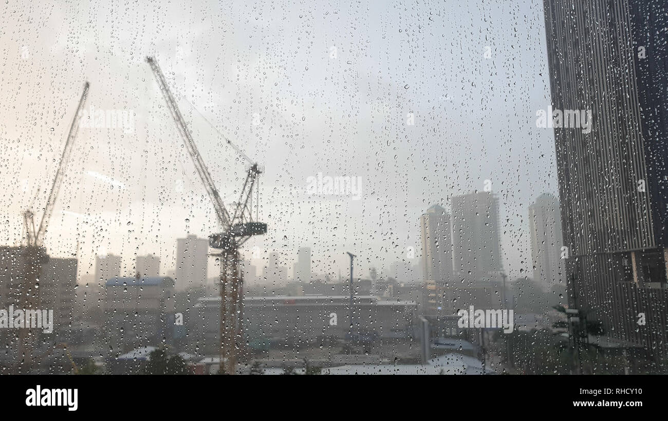 A crane in heavy rain is working on building a skyscraper Stock Photo ...