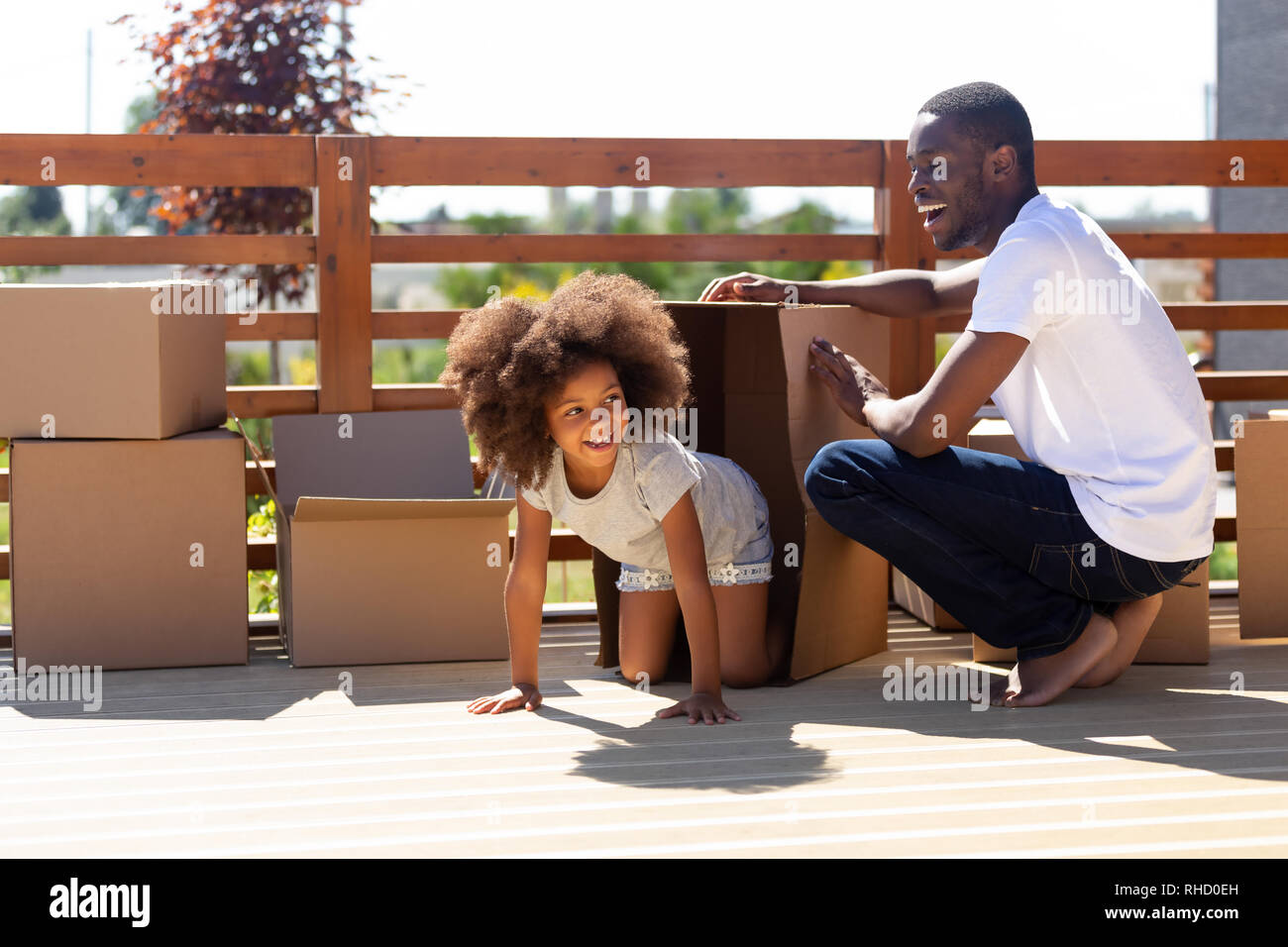 Happy african dad and kid playing with boxes on porch Stock Photo - Alamy