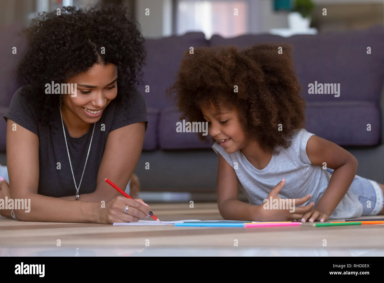 Happy mixed-race mom and kid daughter draw with colored pencils Stock ...