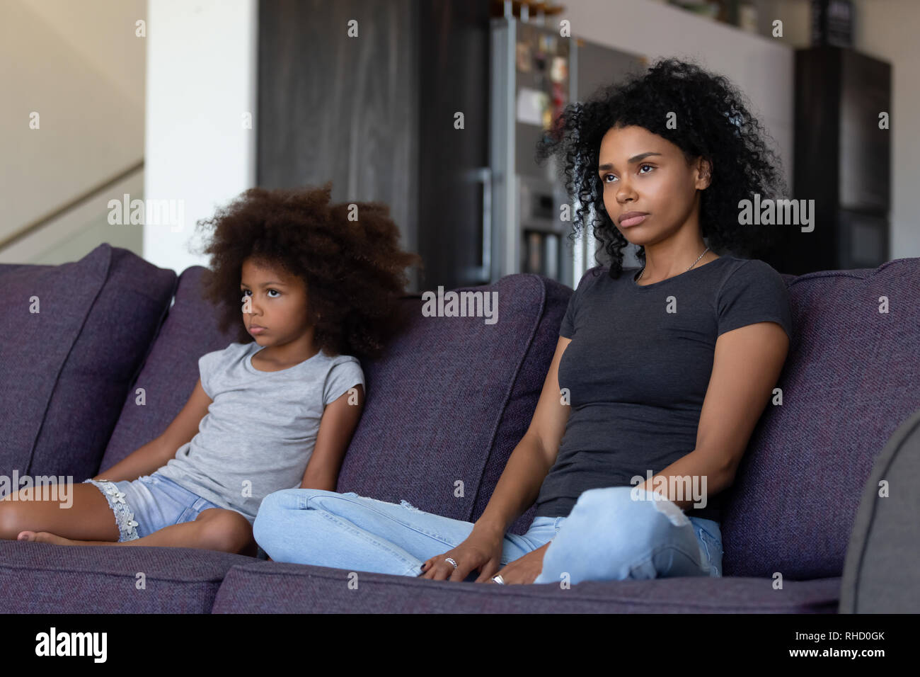 Sulky african child and mother sitting on sofa not talking Stock Photo ...
