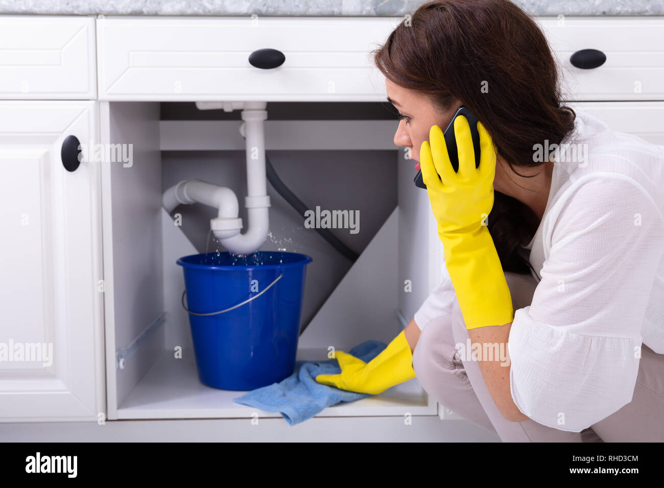 Sad Young Woman Calling Plumber In Front Of Water Leaking From Sink ...