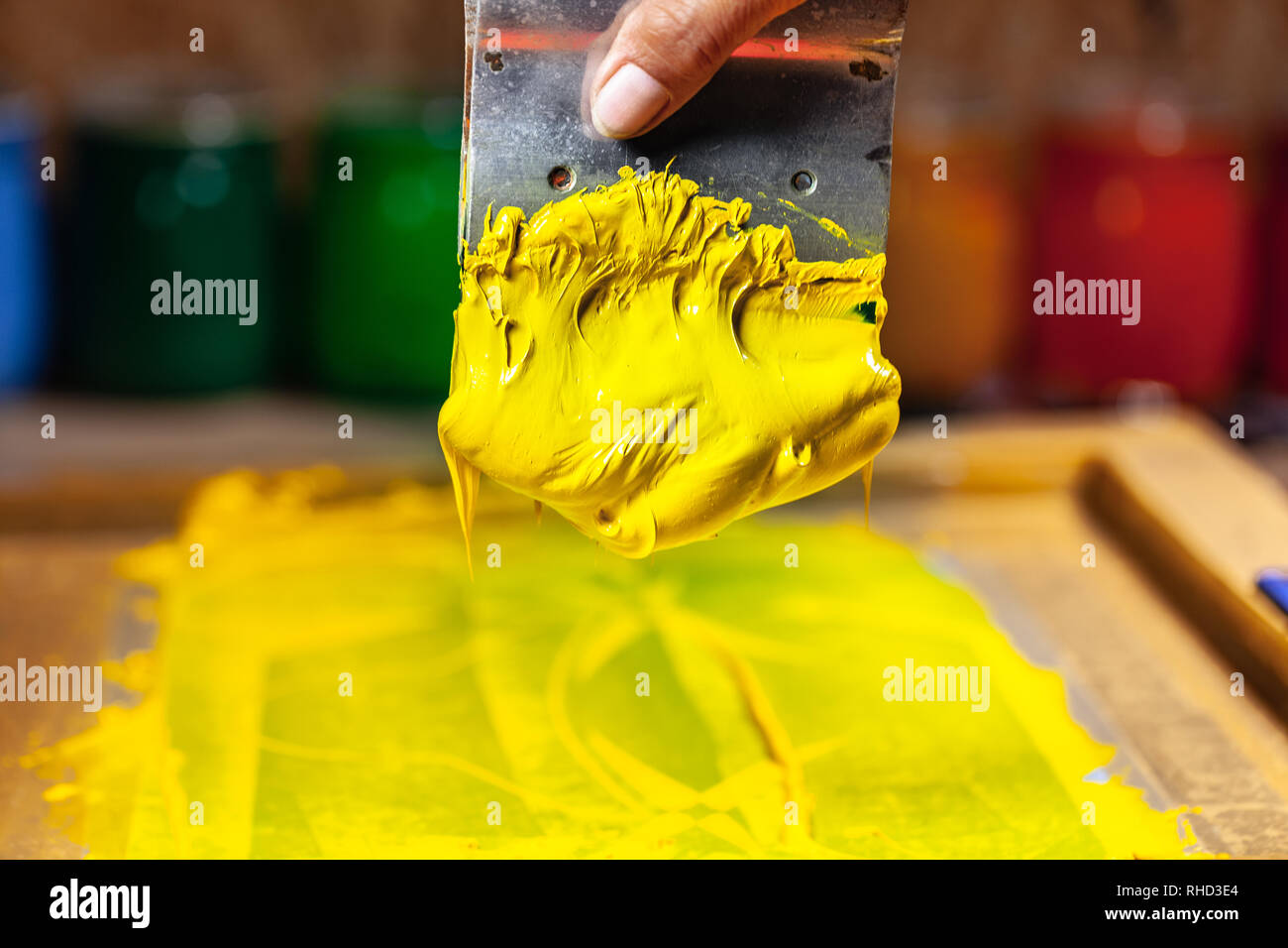 yellow color dripping from hand screen printing during printing tee ...