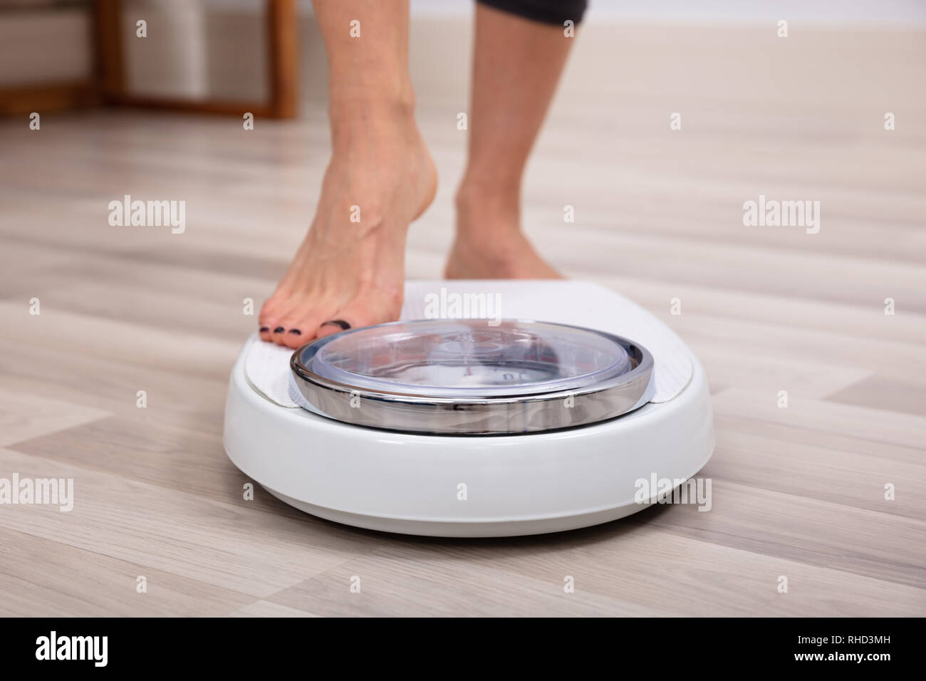 Woman stepping on a scale hi-res stock photography and images - Alamy