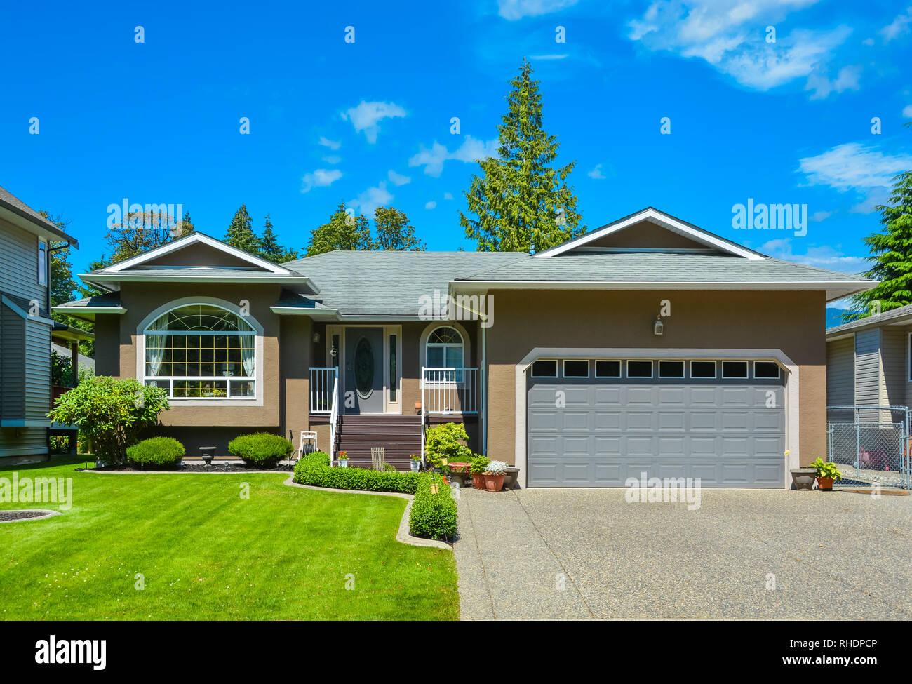 Suburban family house with nice lawn, wide garage door, and concrete ...