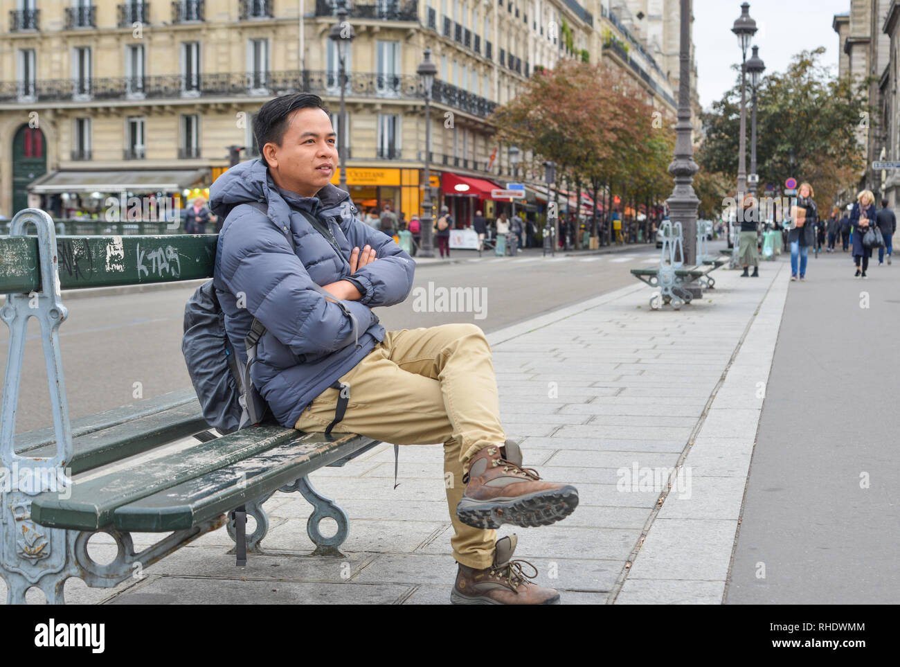 Paris, France - Oct 2, 2018. A man sitting on vintage bench in Paris ...