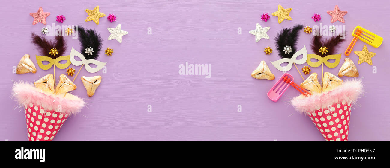 Purim celebration concept (jewish carnival holiday) over wooden purple ...