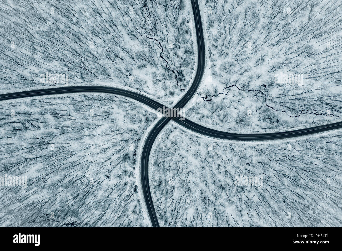Aerial view of road intersection in the forest at winter. Drone shot ...