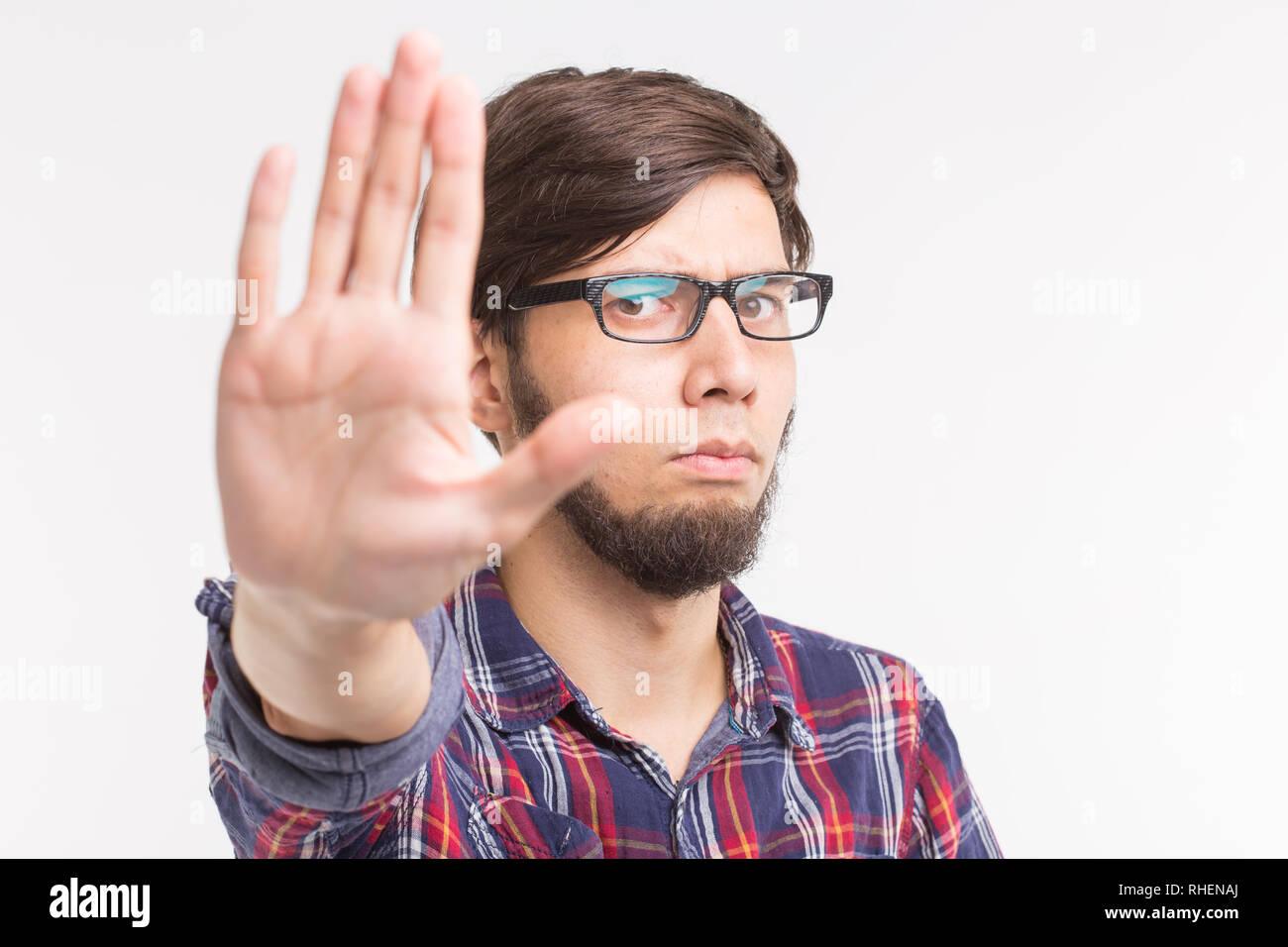 People, expression and gesture concept - young man showing stop gesture ...