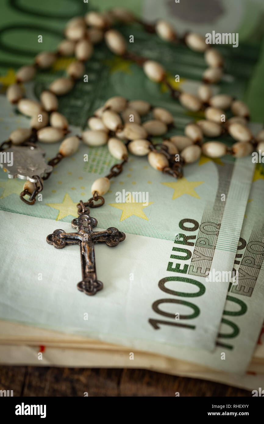 Catholic cross on a background of money / concept Stock Photo - Alamy
