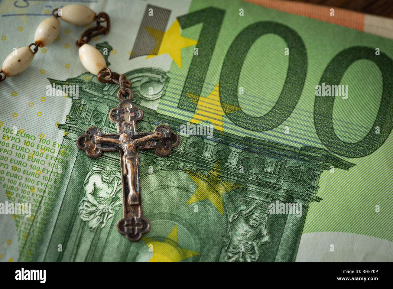 Catholic cross on a background of money / concept Stock Photo - Alamy