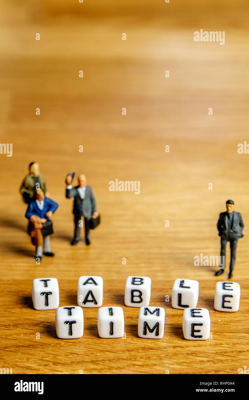 little miniature figurines with little dices forming specific word as a ...