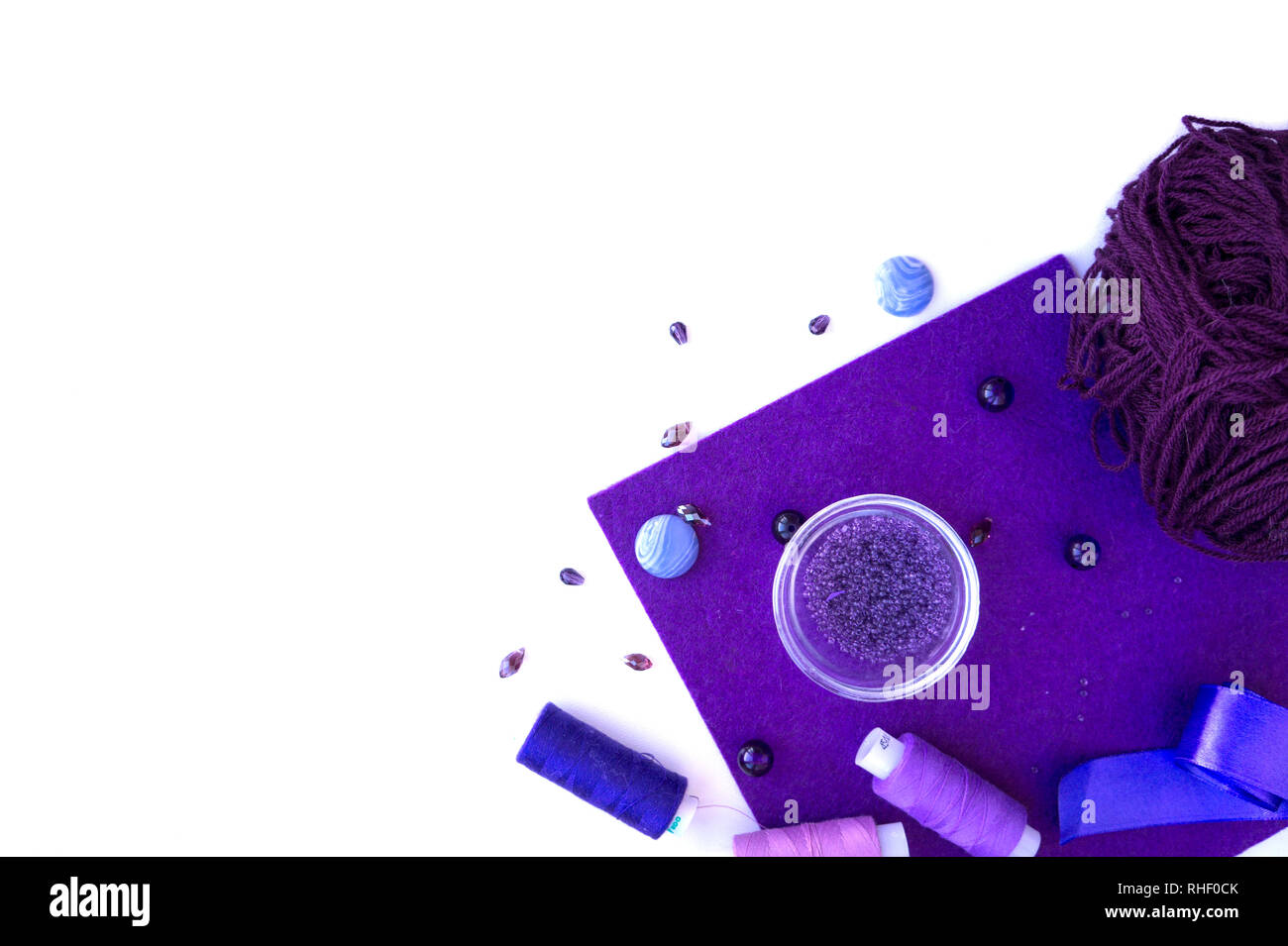A set of materials for needlework in violet color on a white background ...