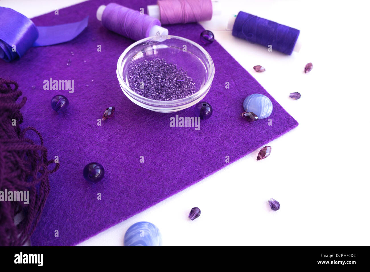 A set of materials for needlework in violet color on a white background ...