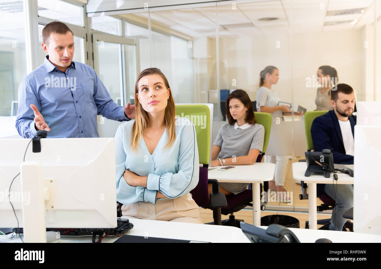 Upset girl sitting at laptop in coworking space while dissatisfied ...