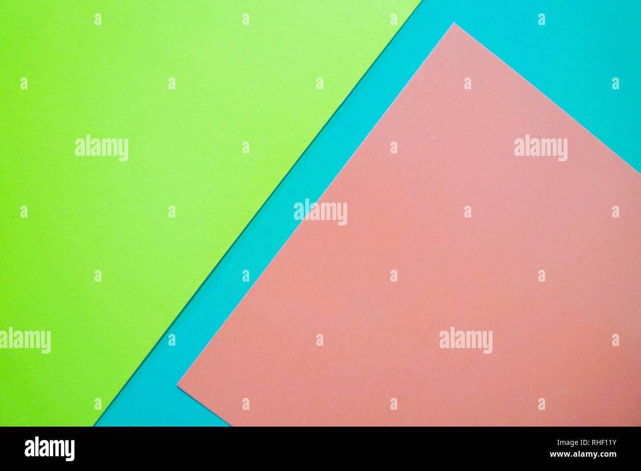 Abstract flat lay background with color paper sheets. Green, pink and ...