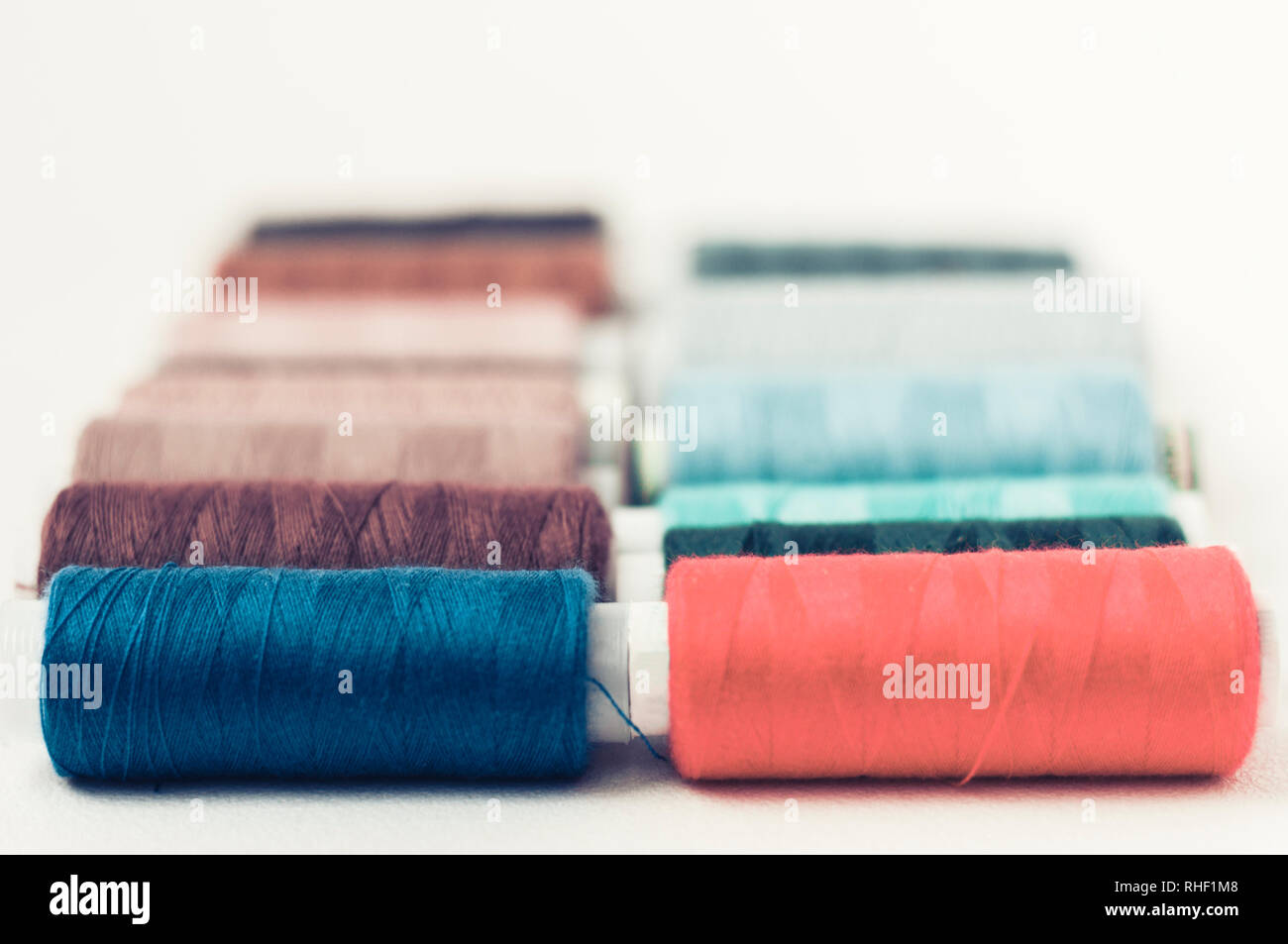 Colored sewing thread coils on white background with copy space for ...