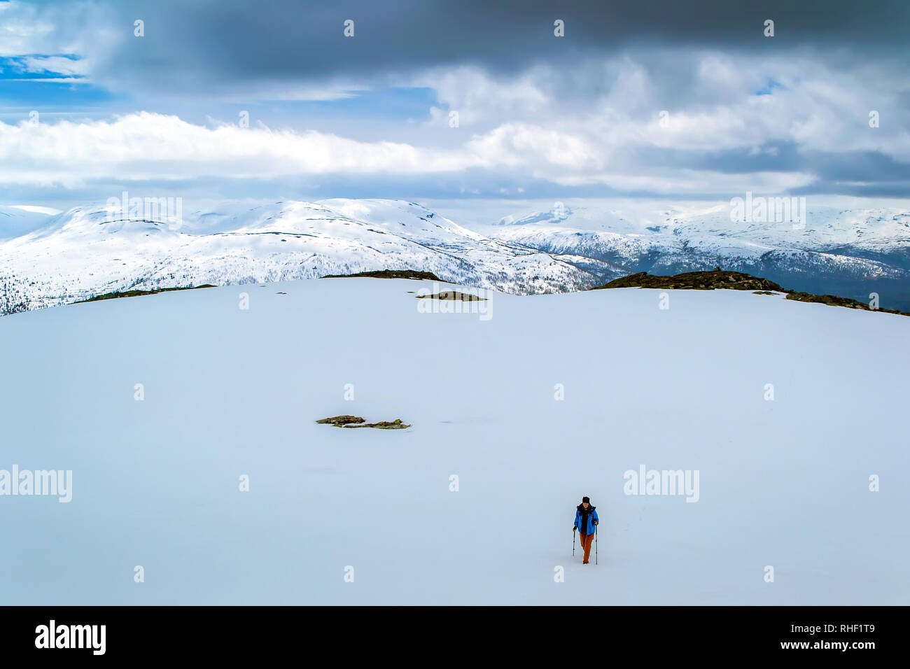Tourist on snow field. Trekking in the snowy winter mountains. Clouds ...