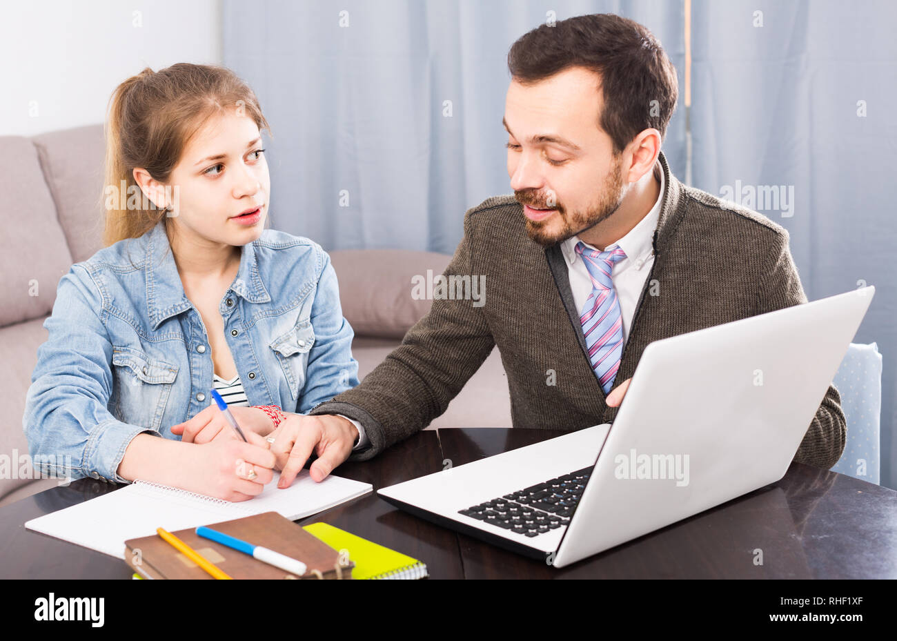 adult italian male tutor assisting his teenage pupil to prepare for ...