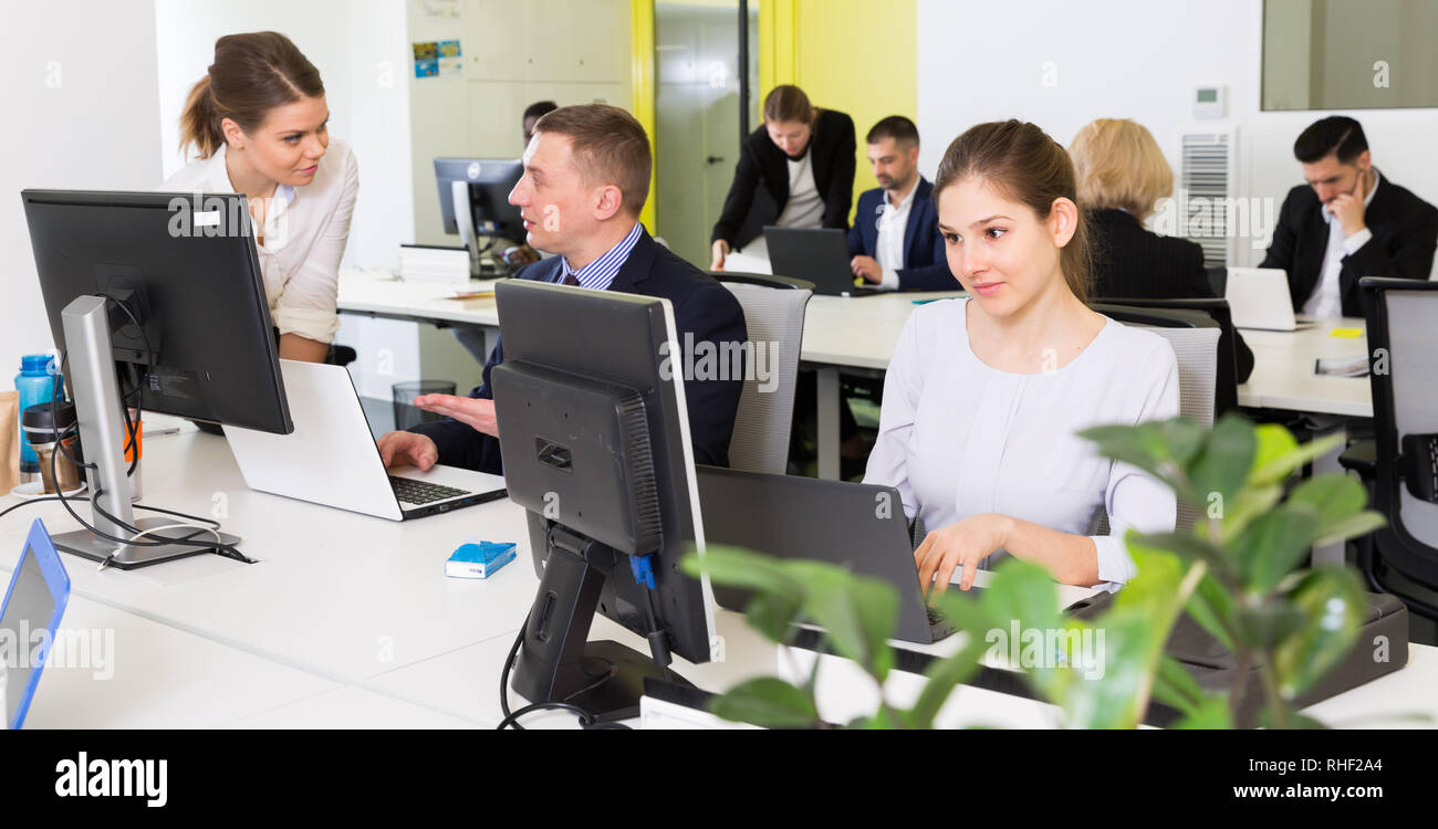 Successful coworkers engaged in business activities in busy open plan ...