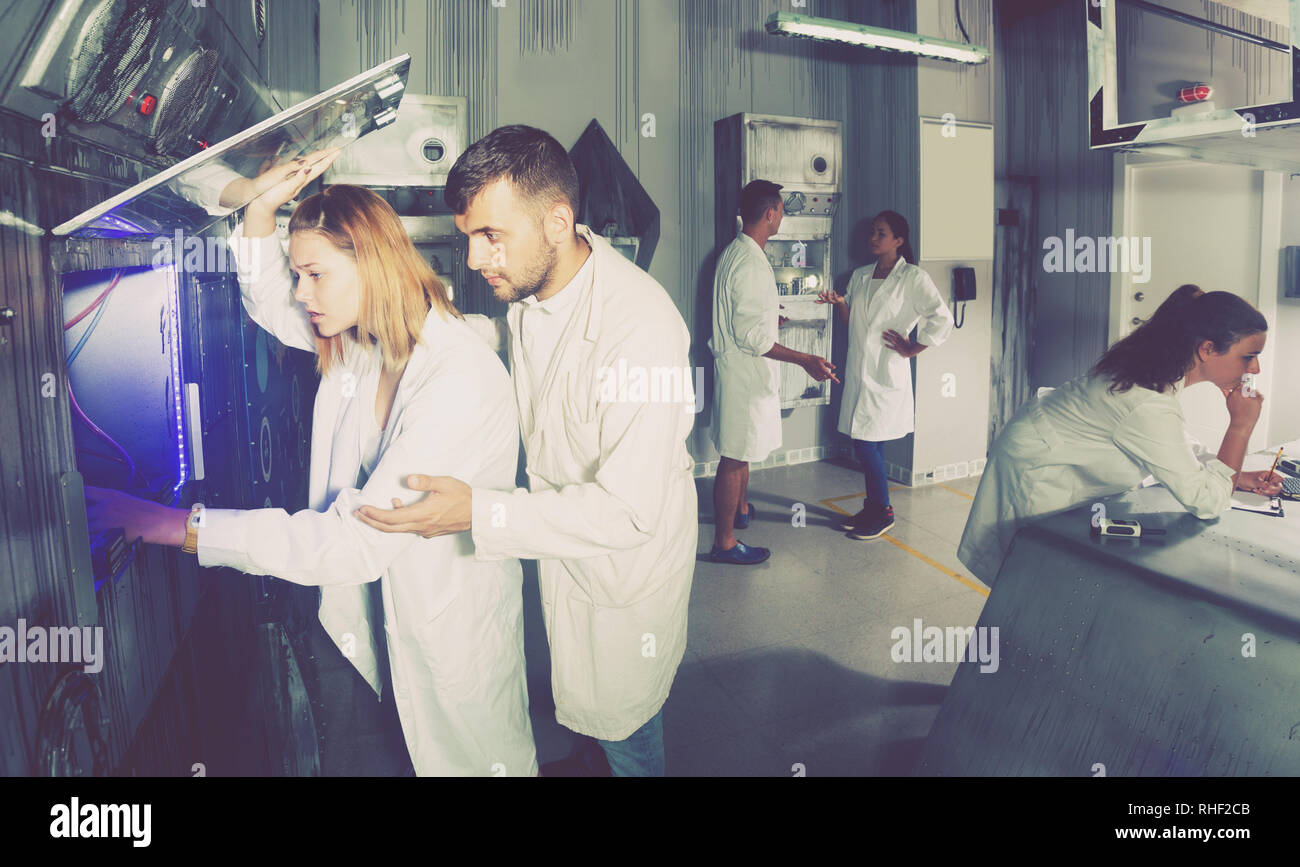 Company of young people trying to solve conundrum in escape room in ...