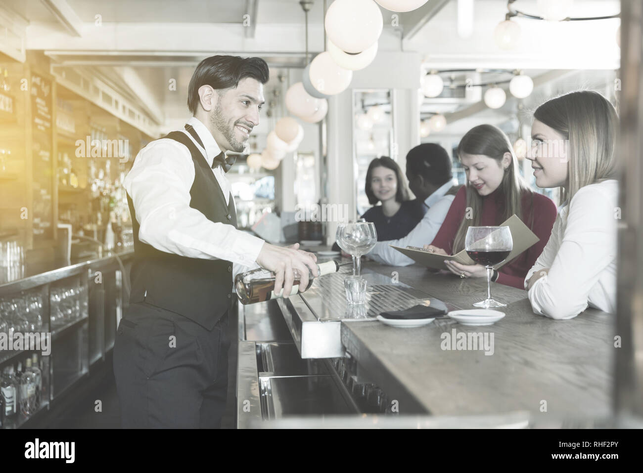 Modern people are relaxing near bar counter and drinking alcohol in ...