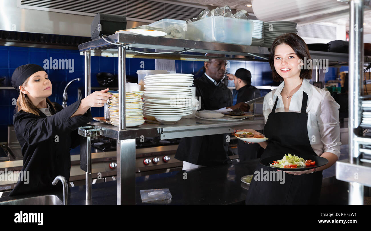 Happy cheerful positive woman waiter is holding tray with order on ...