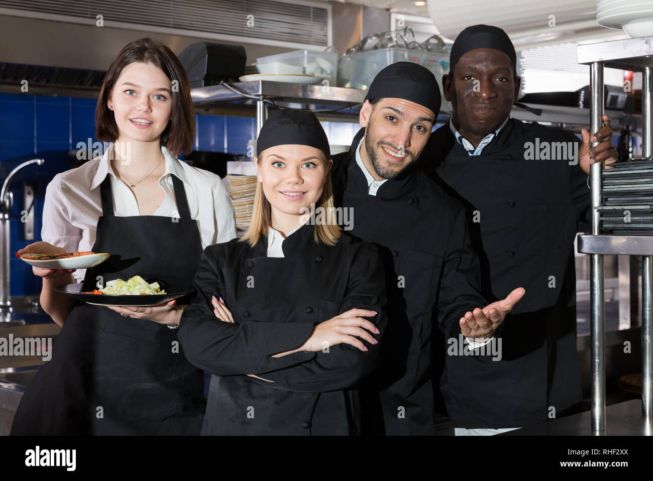 Positive multinational team of restaurant staff standing together in ...