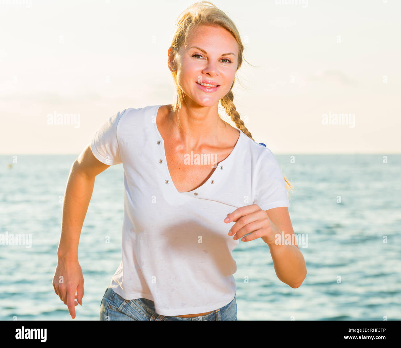 Sportswoman is jogging on the beach near the ocean Stock Photo - Alamy