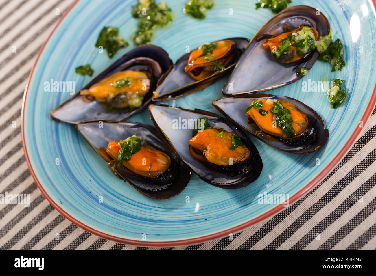 Plate with mediterranean seafood dish black shell mussels with herbs ...
