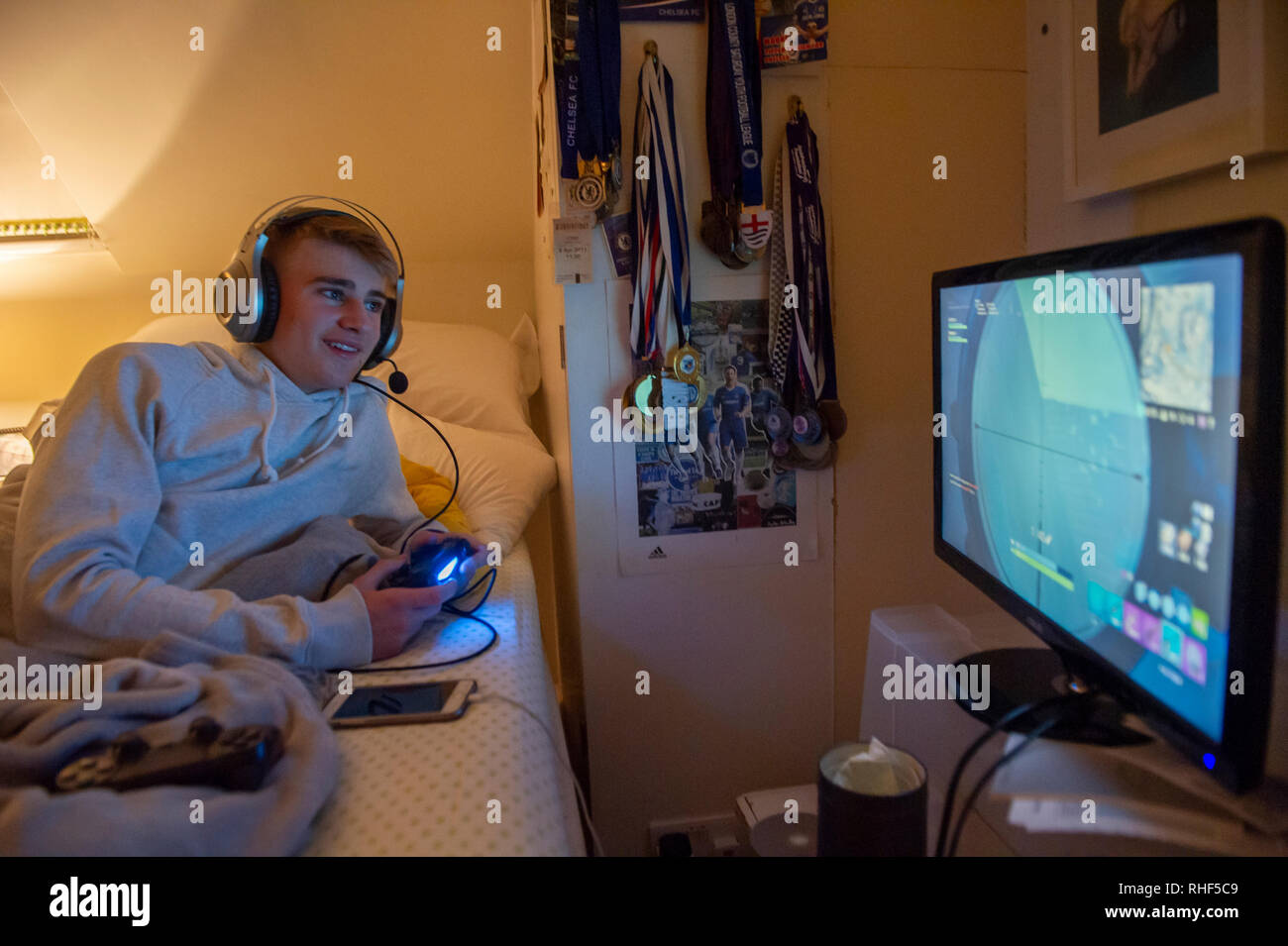 A teenaged boy playing computer games in his bedroom Stock Photo - Alamy