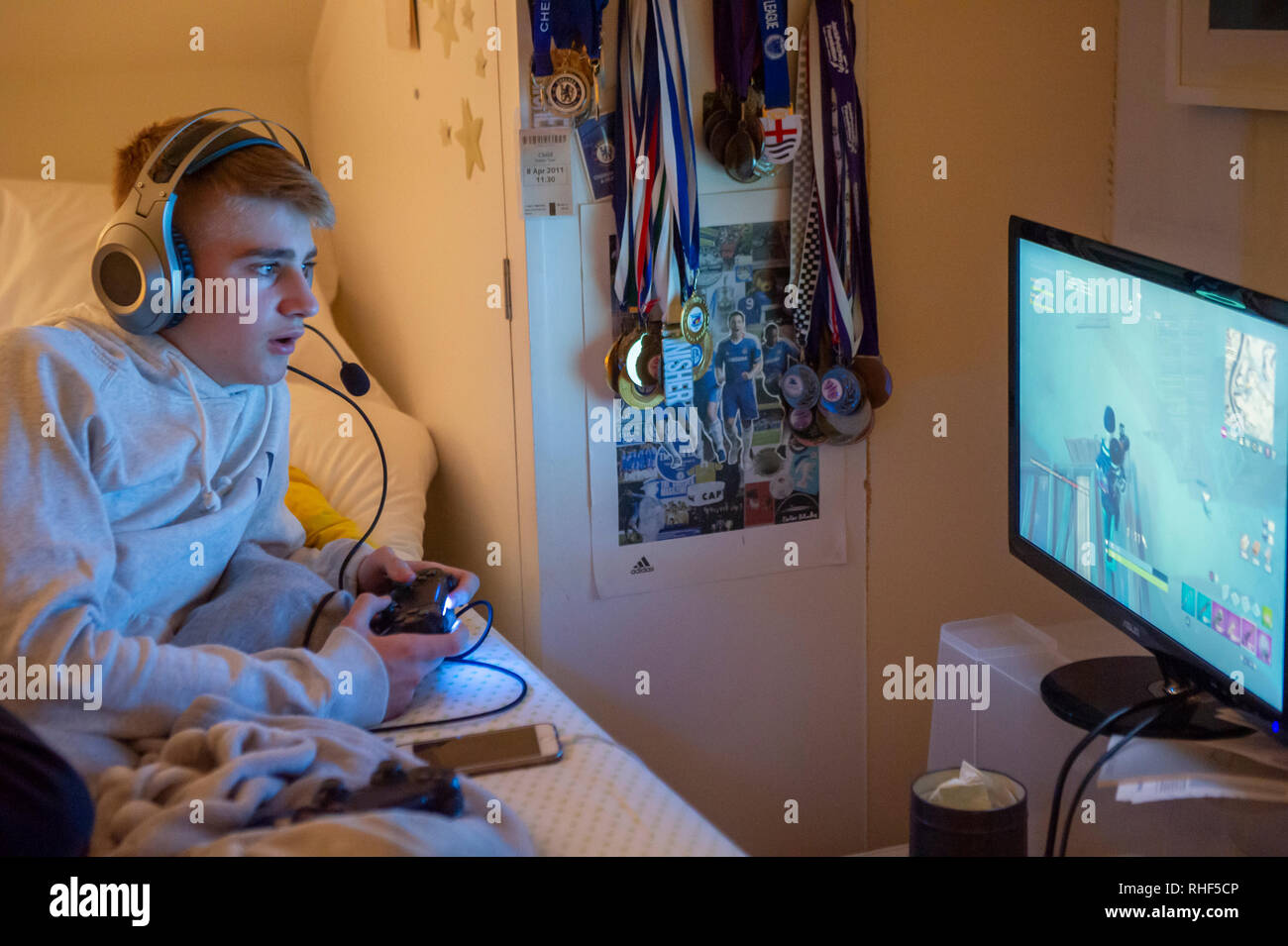 A teenaged boy playing computer games in his bedroom Stock Photo - Alamy