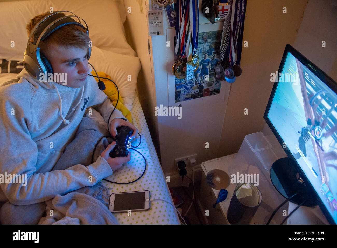 A teenaged boy playing computer games in his bedroom Stock Photo - Alamy