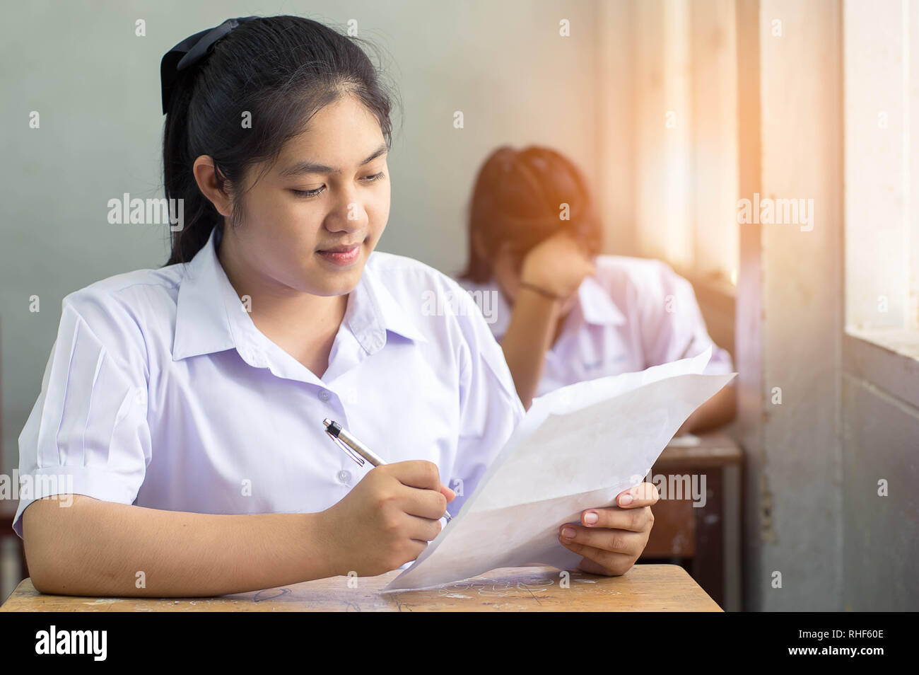 Portrait of young girl students writing the exam with smile Stock Photo ...