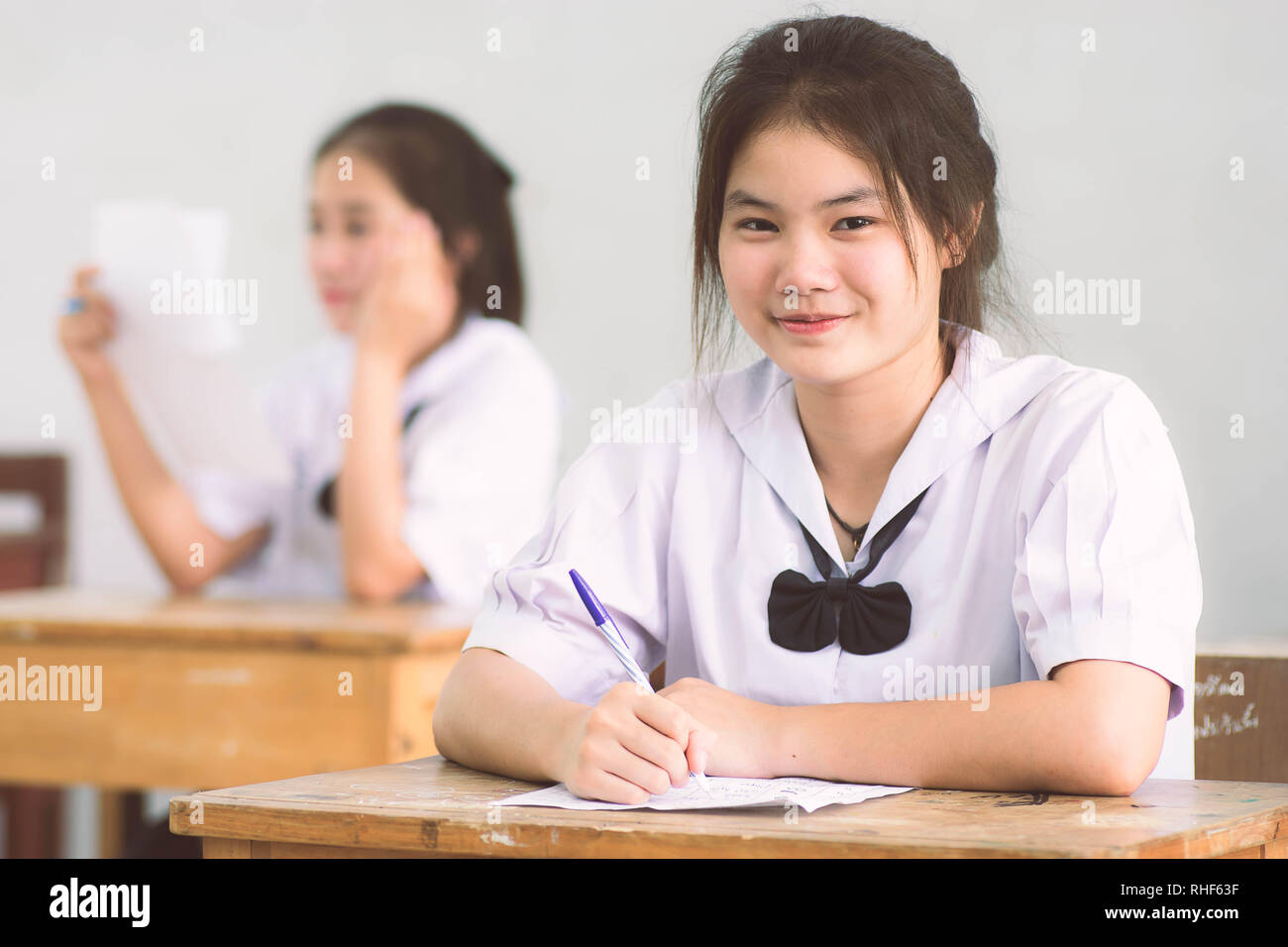 Smile young girl student reading and writing exam with not stress Stock ...