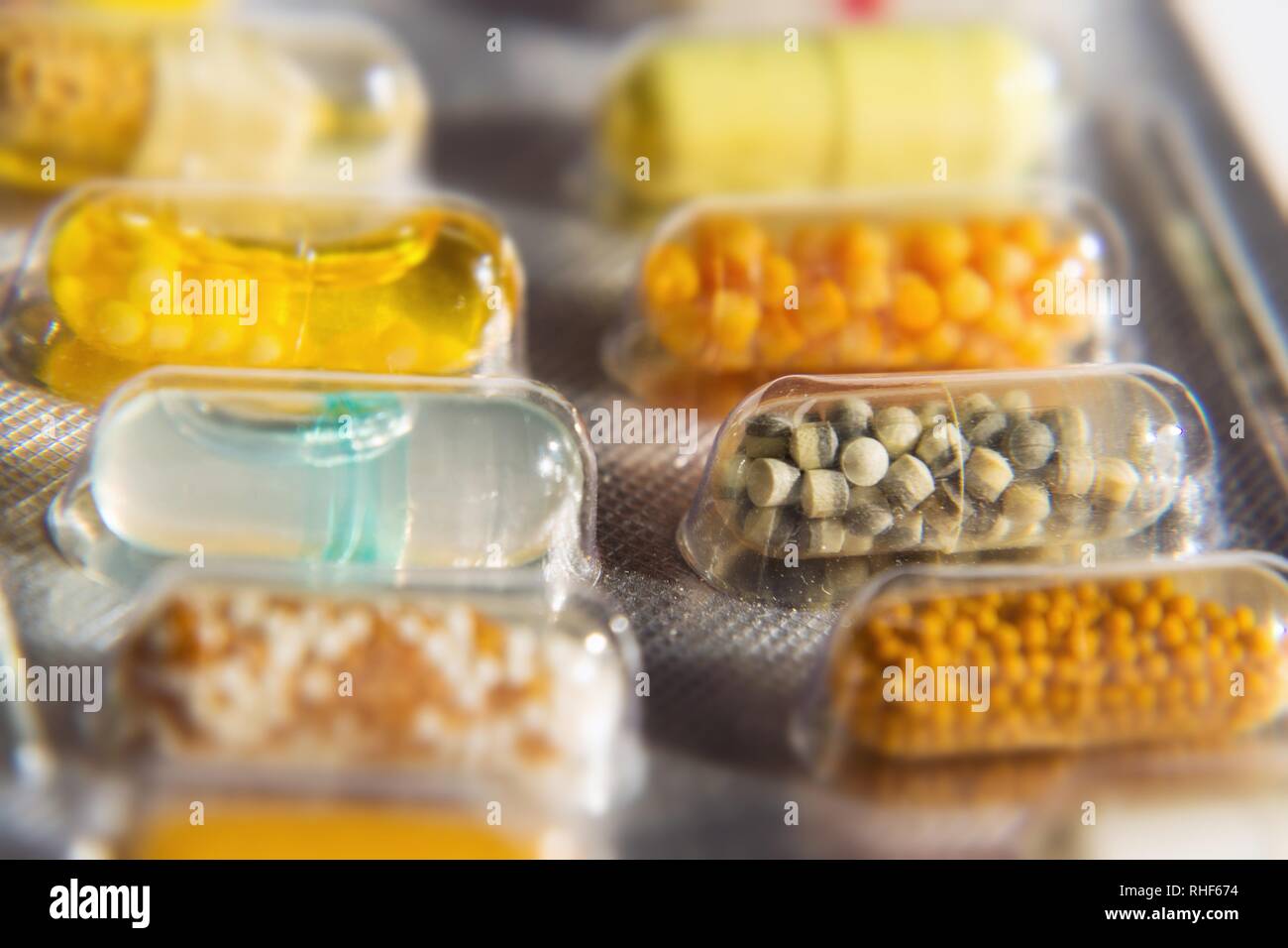 Various colorful pills in transparent medicine capsule detail isolated ...