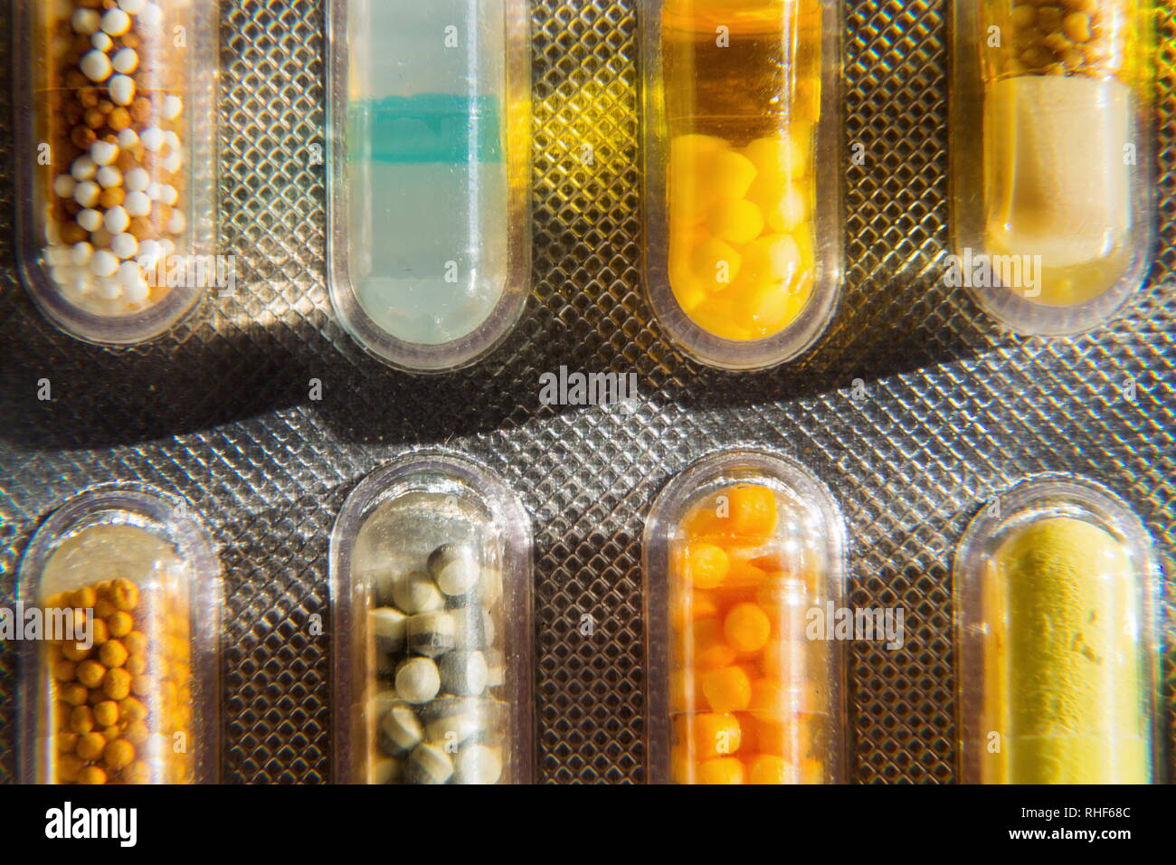 Various colorful pills in transparent medicine capsule detail isolated ...