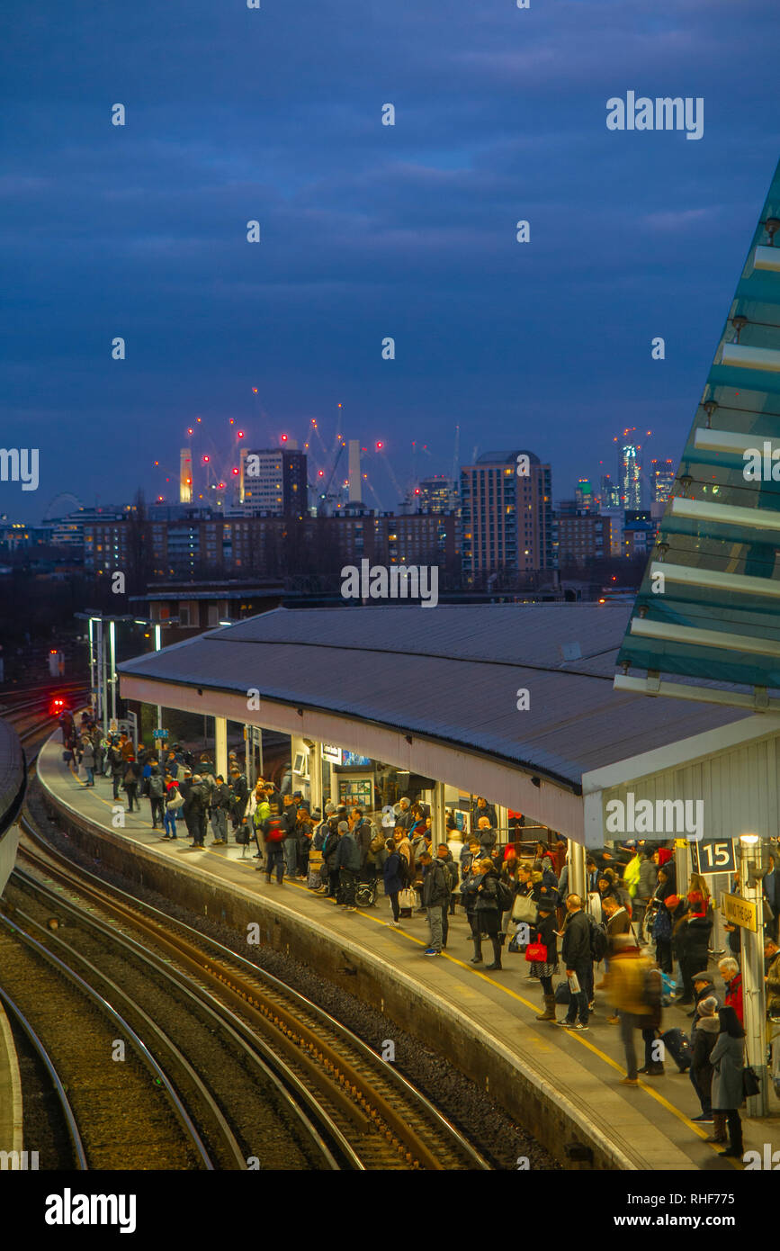 Trains at Clapham Junction station at dusk with Battersea Power Station ...