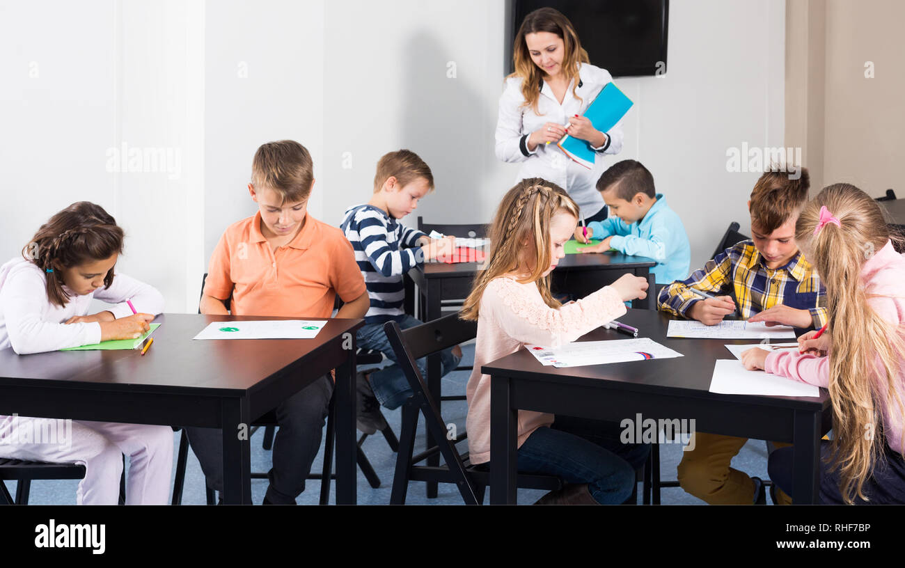 Children in elementary age drawing at classroom in school Stock Photo ...